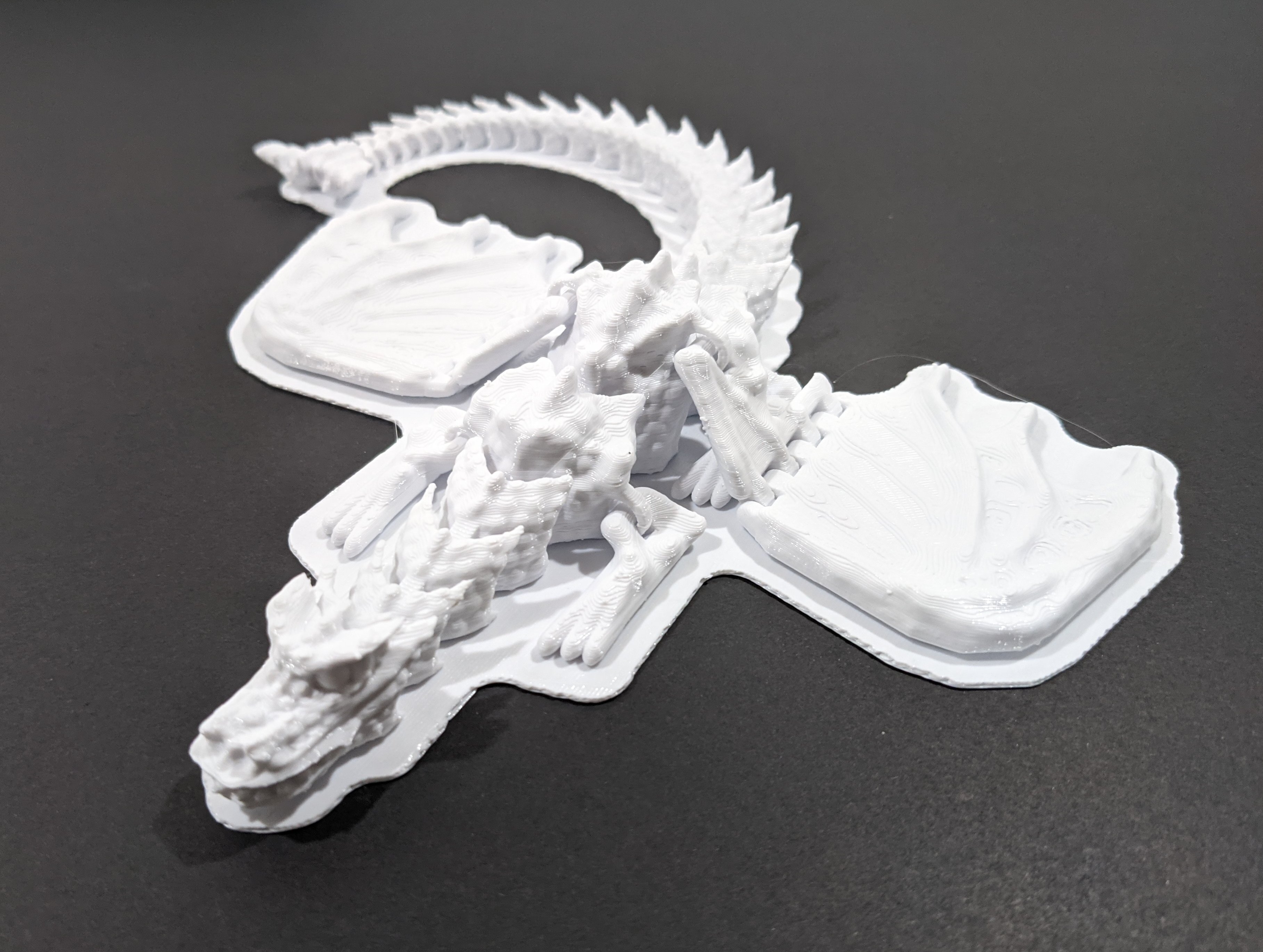 STL file WINGED DRAGON ARTICULATING FLEXI WIGGLE PET, PRINT IN PLACE 🐉 ...